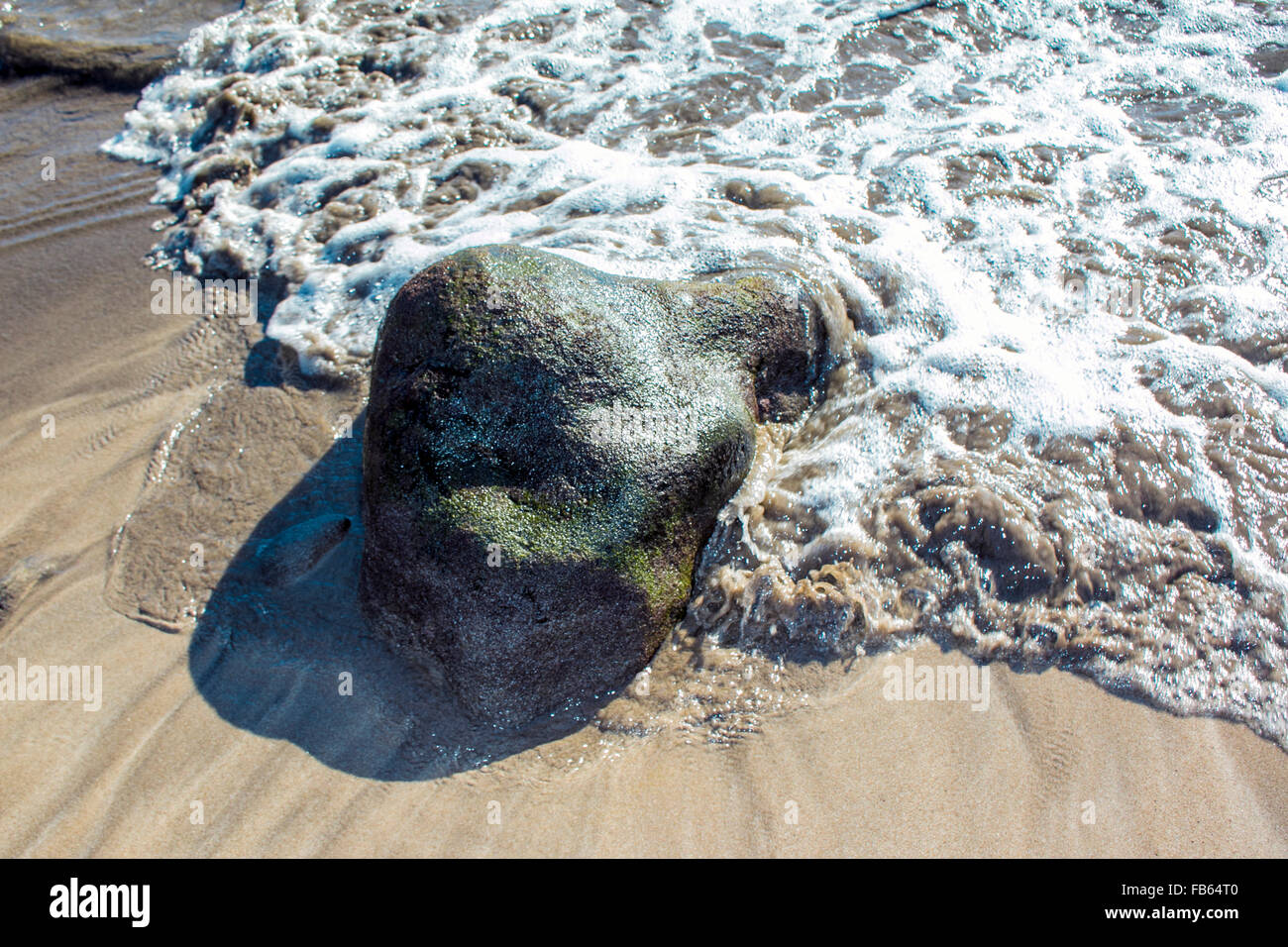 Sea waves lash line impact rock on the beach Stock Photo - Alamy