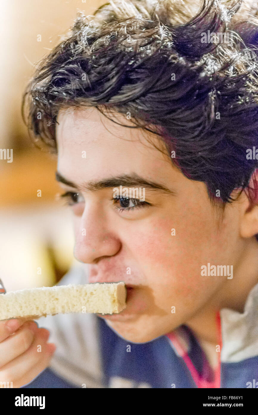 close portrait of Caucasian boy with reassuring look eating bread in ...