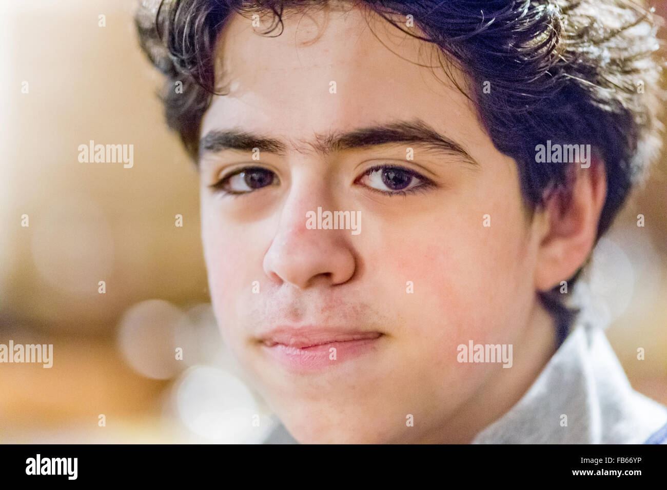 close portrait of Caucasian boy with reassuring look in warm and bright ...