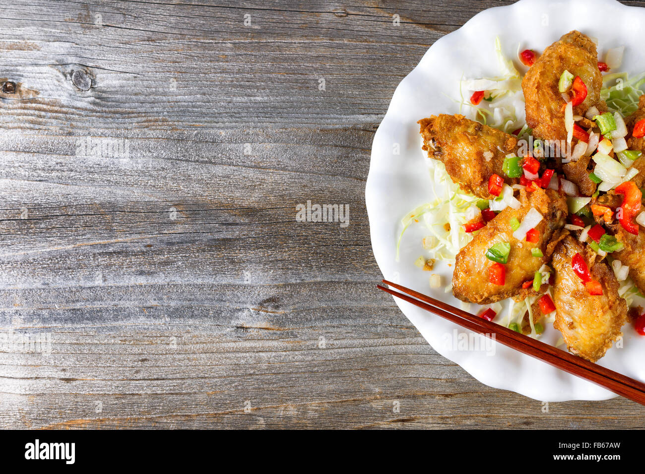 Top view of a partial fried Asian style chicken wings in white plate ...