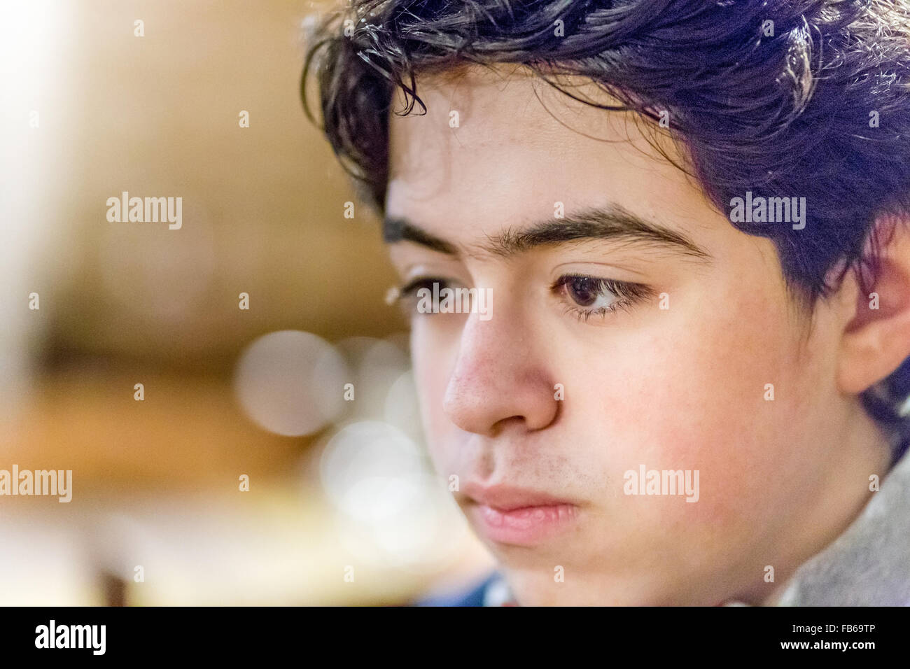 close portrait of deep in thought Caucasian boy in warm and bright ...