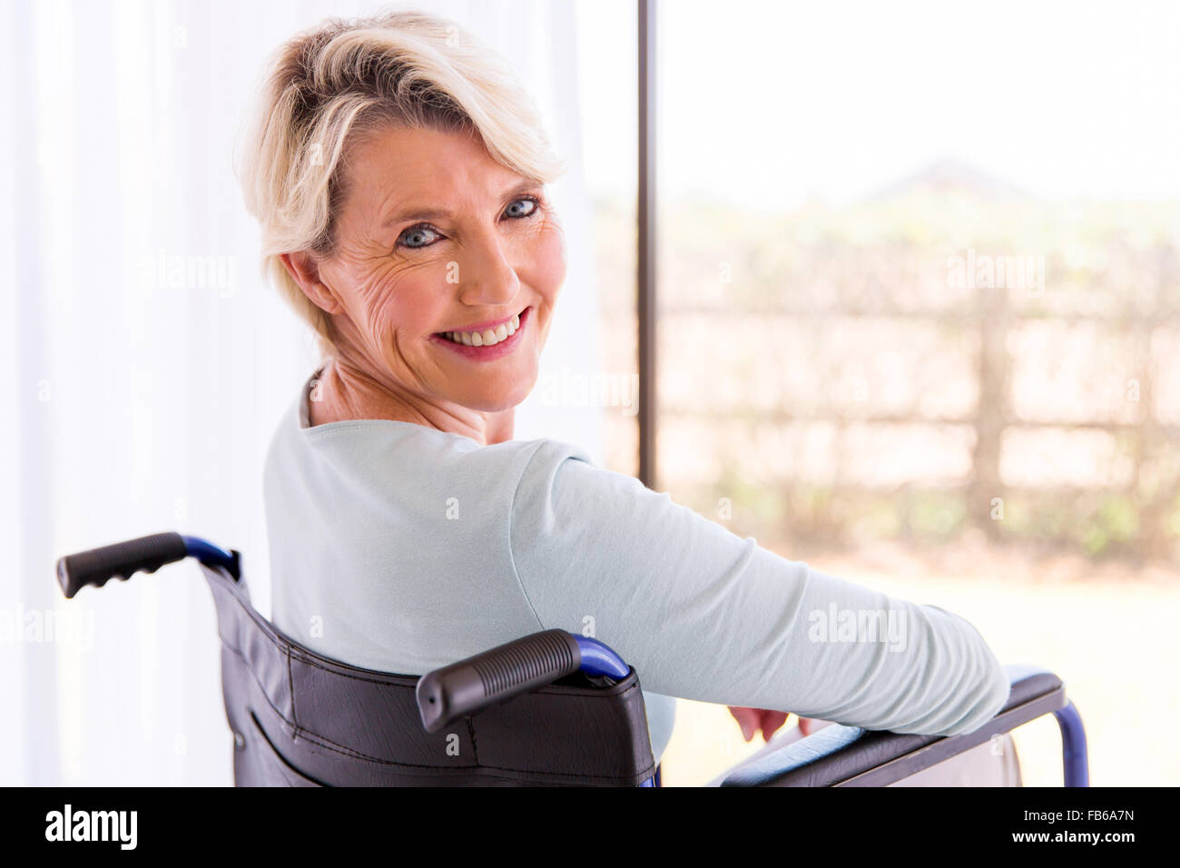 happy disabled woman in wheelchair looking back Stock Photo - Alamy
