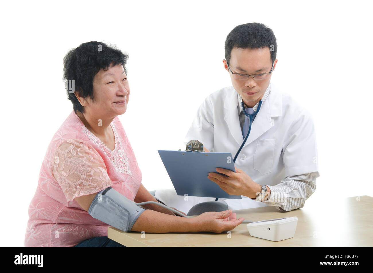 Image of a doctor and his nurse checking up a senior patient in the ...