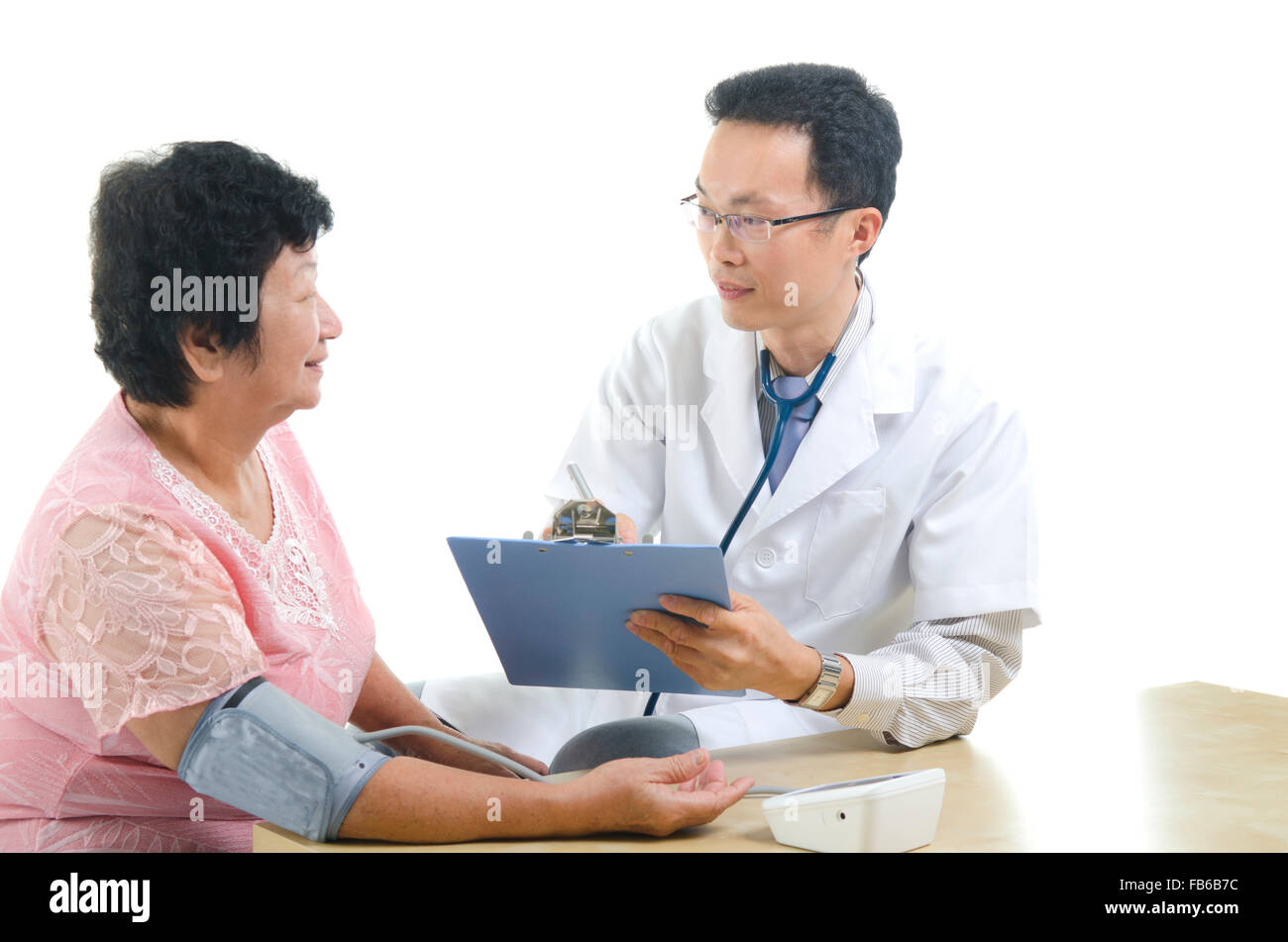 Image of a doctor and his nurse checking up a senior patient in the ...