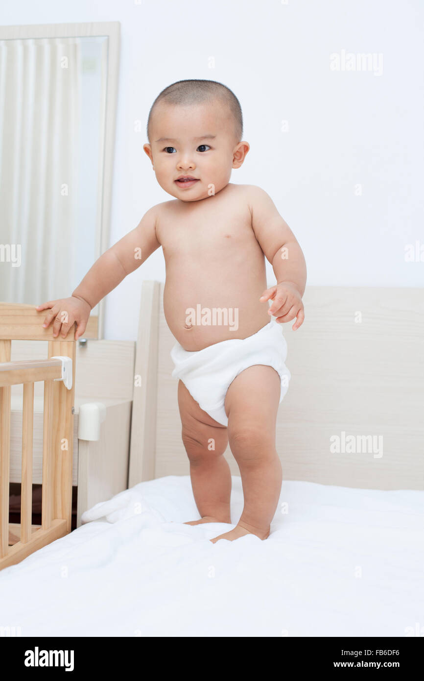 Cute Chinese baby boy standing by his Crib, shot in Beijing, China ...