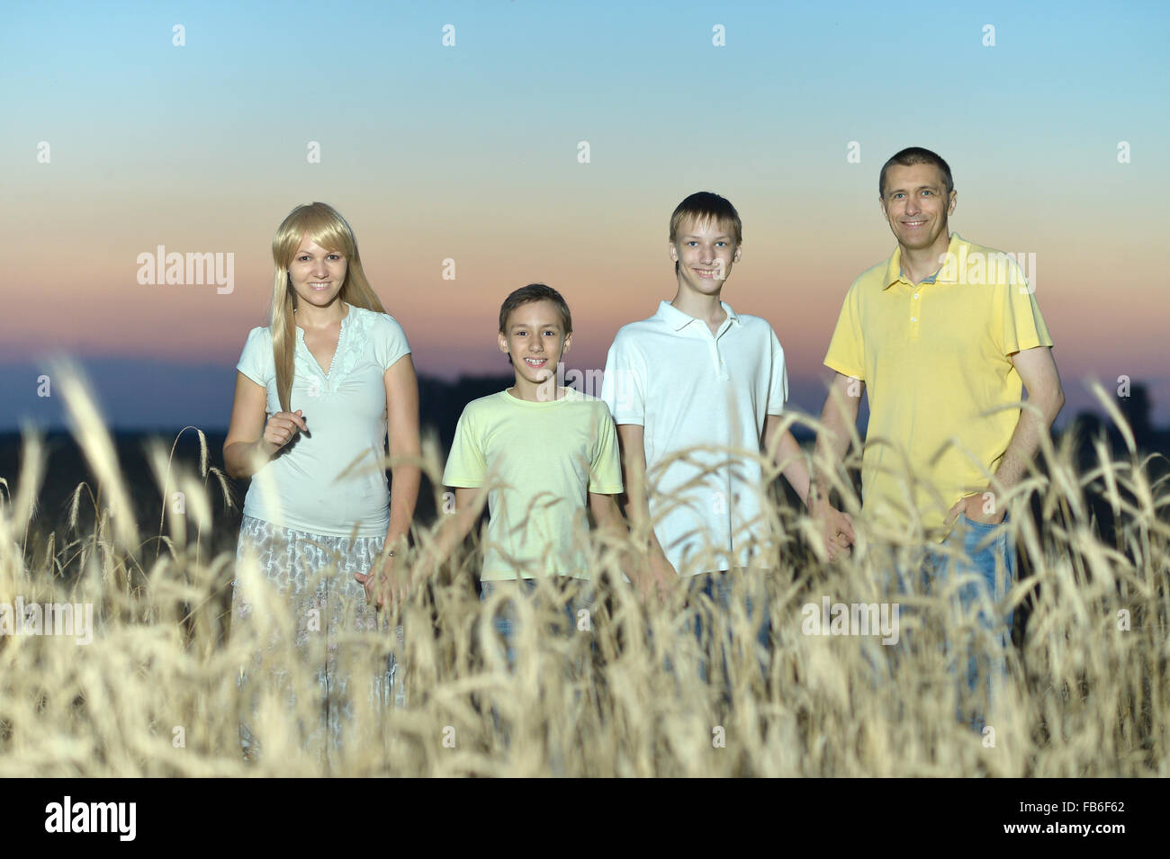 Happy family in wheat field Stock Photo - Alamy