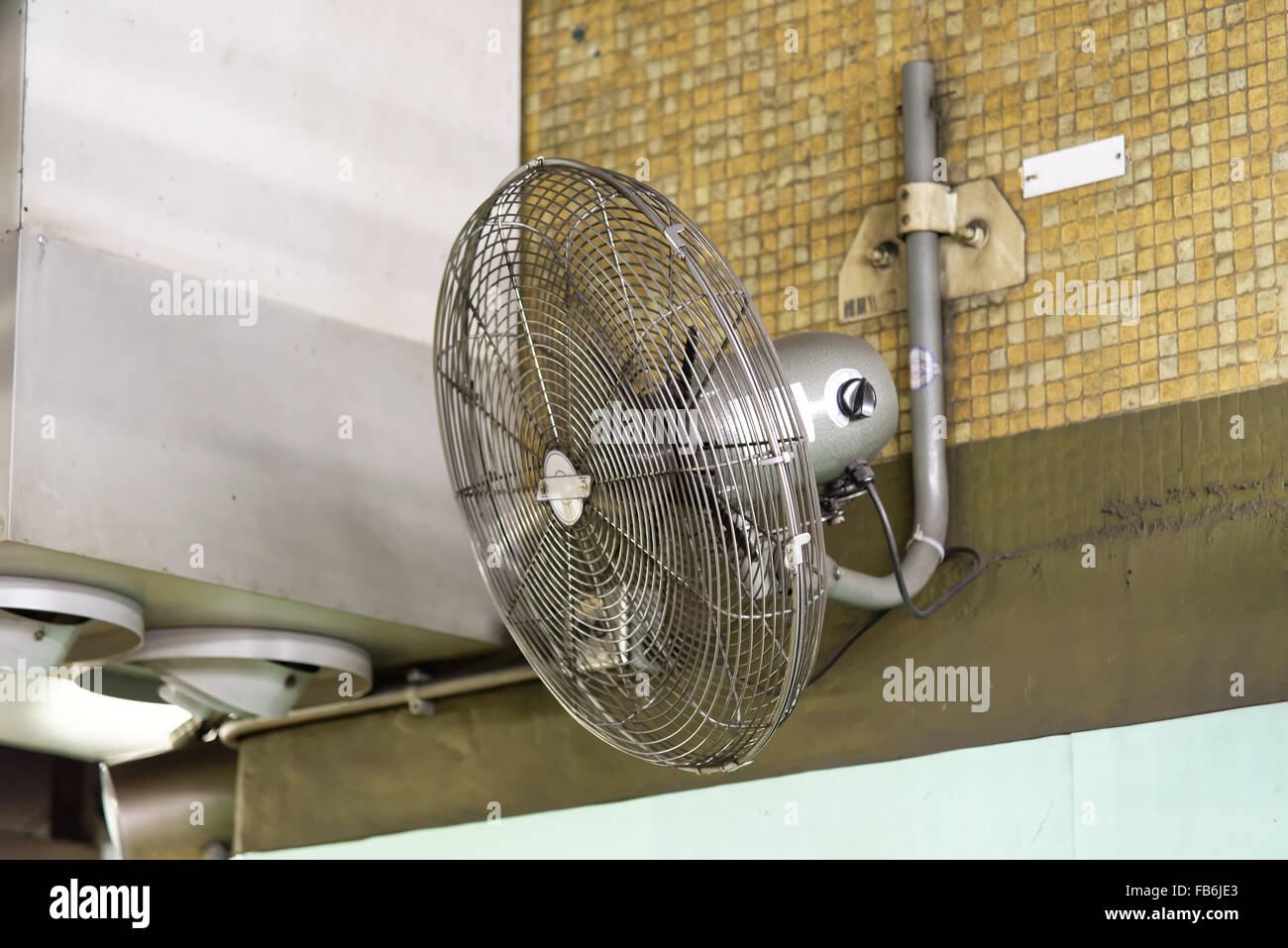 Public fan hanging from a wall Stock Photo - Alamy