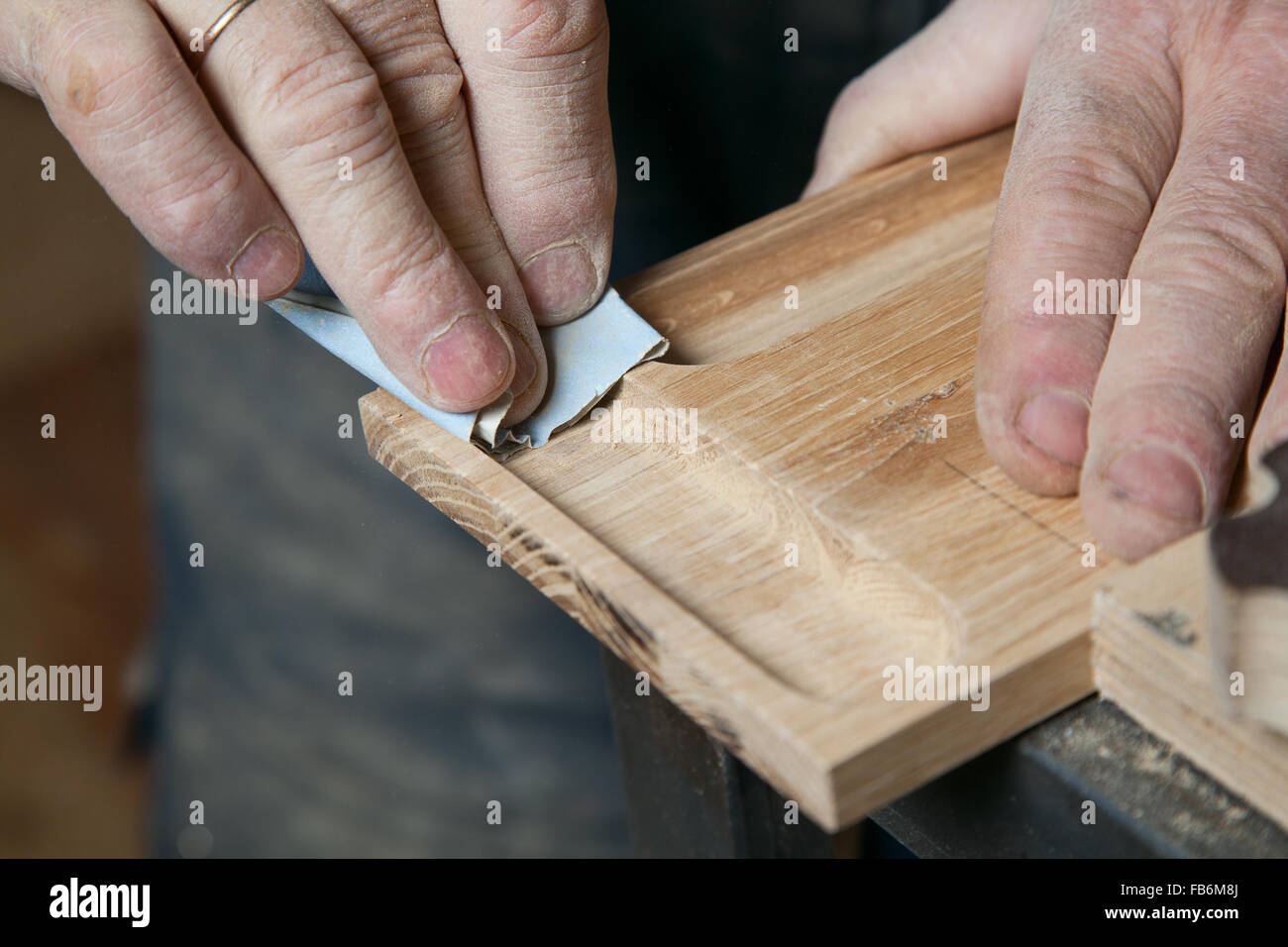 Men sandpaper grinds wood product in a workshop Stock Photo - Alamy