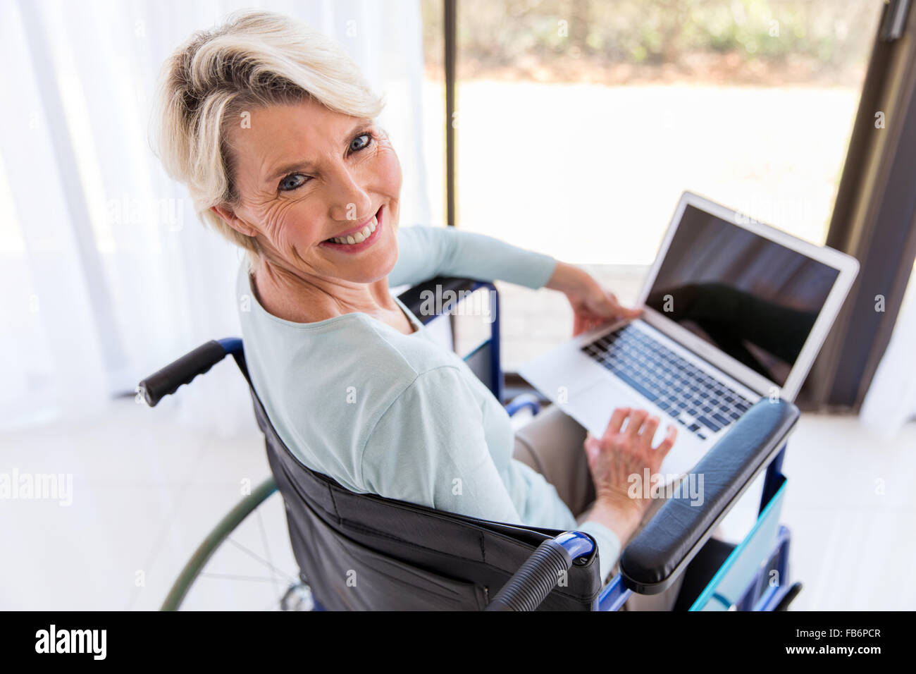pretty disabled middle aged woman with laptop computer at home Stock ...