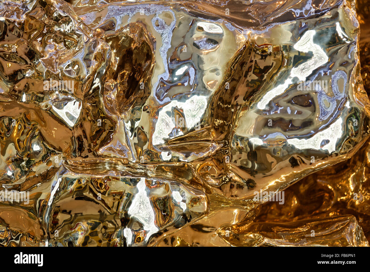 liquid metal reflective sculpture closeup in a warm light Stock Photo ...