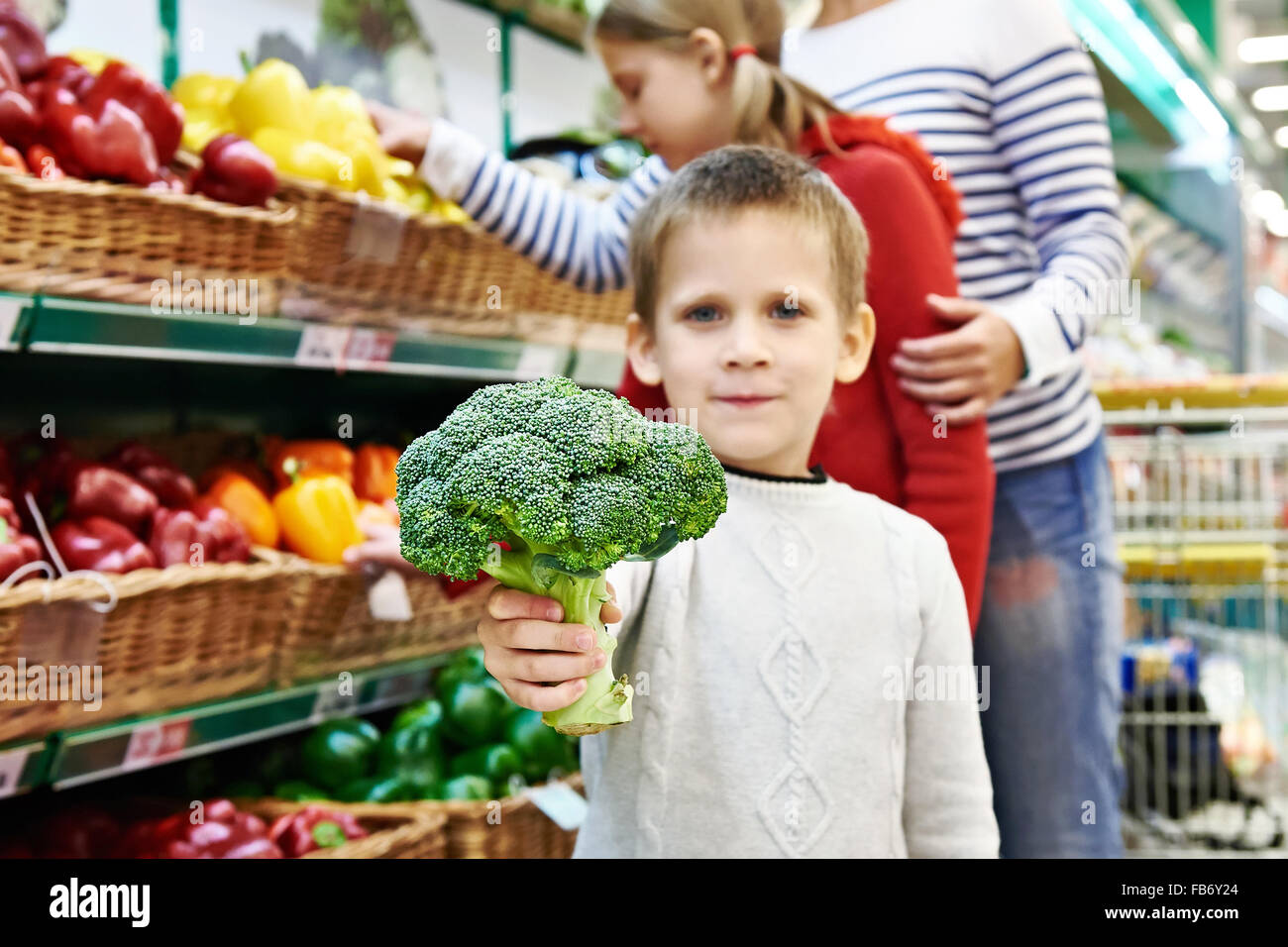 Boy shows broccoli in supermarket Stock Photo - Alamy