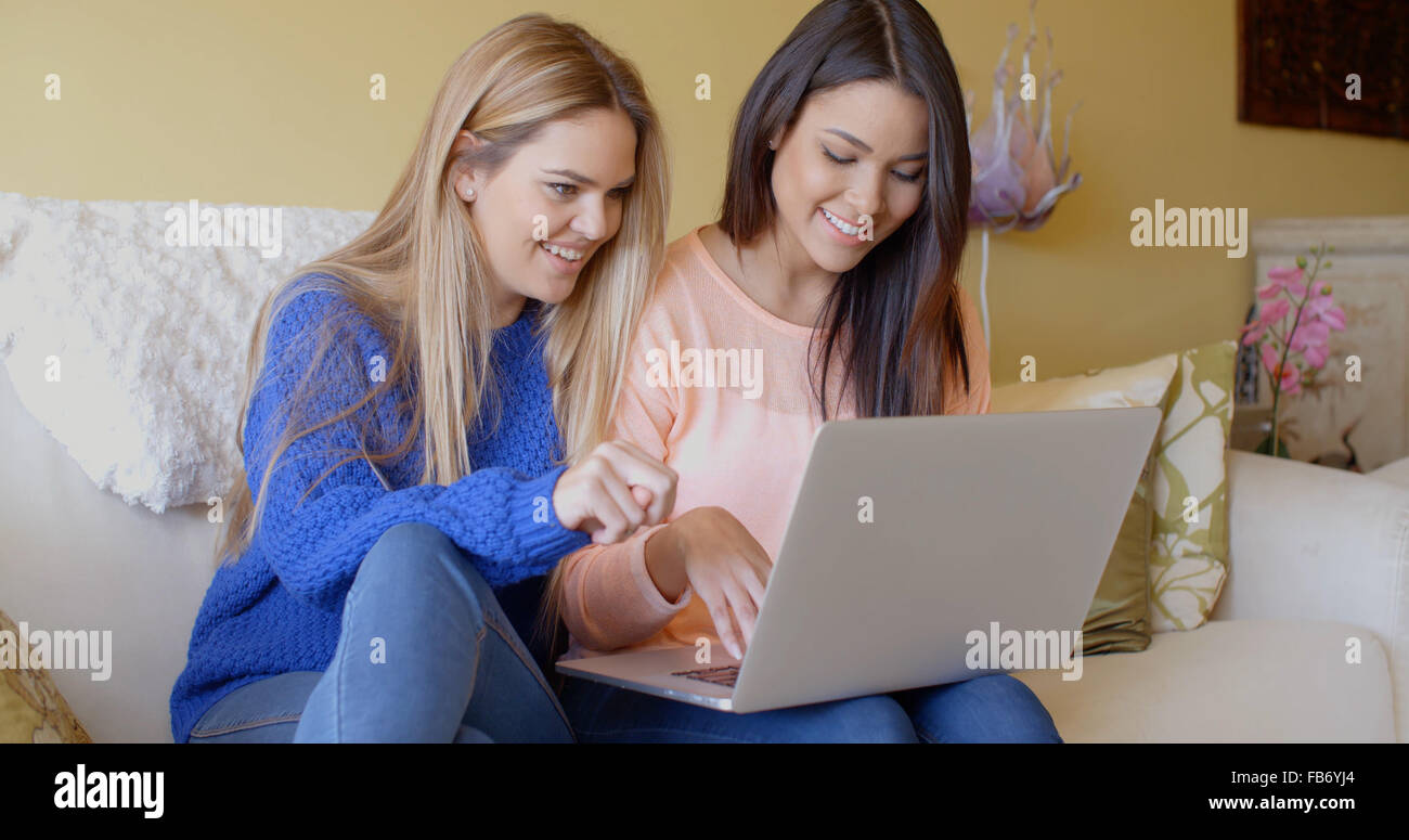 Two happy young women browsing the internet Stock Photo - Alamy