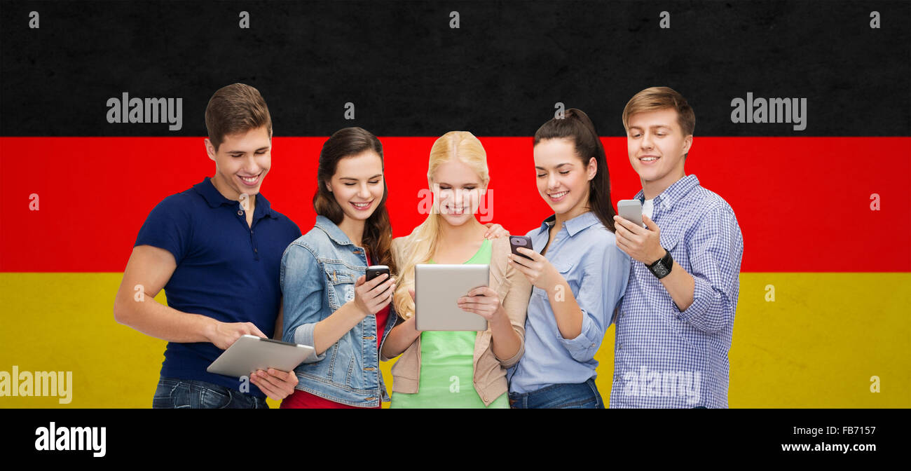 smiling students using smartphones and tablet pc Stock Photo - Alamy
