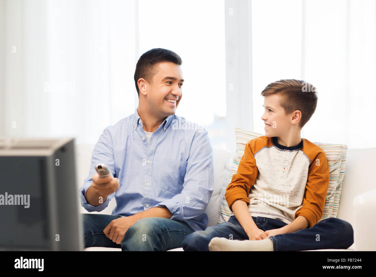 smiling father and son watching tv at home Stock Photo - Alamy