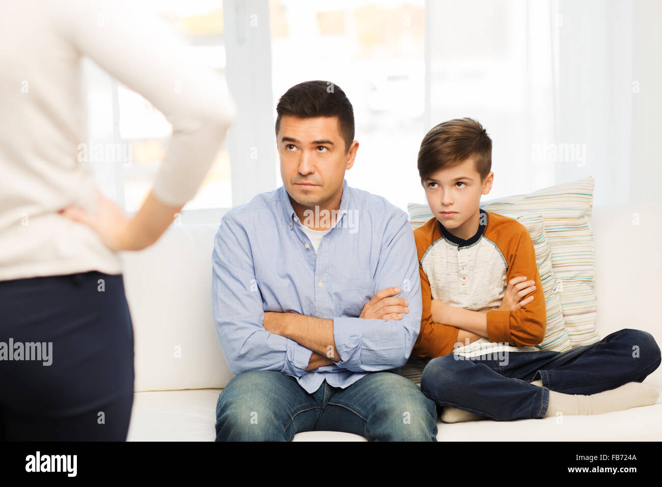 upset or displeased father, son and mother at home Stock Photo - Alamy