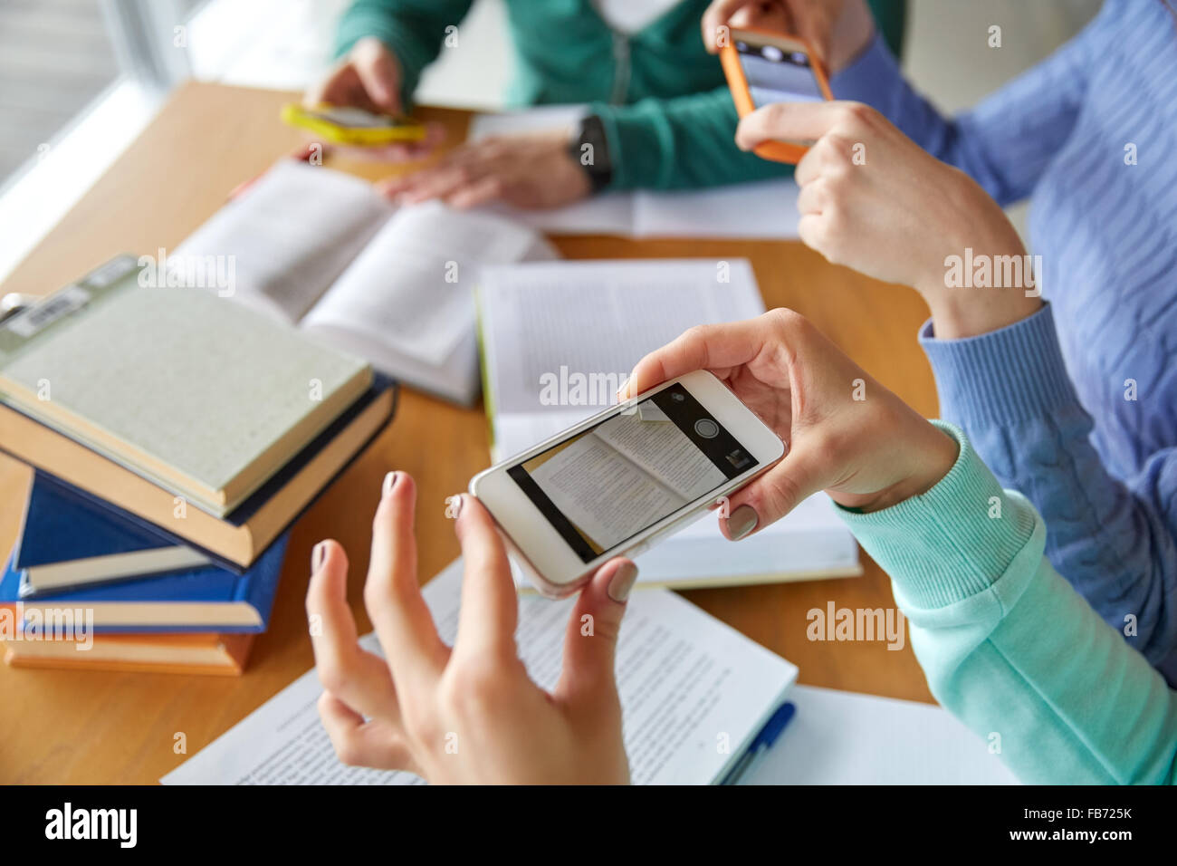 students with smartphones making cheat sheets Stock Photo - Alamy