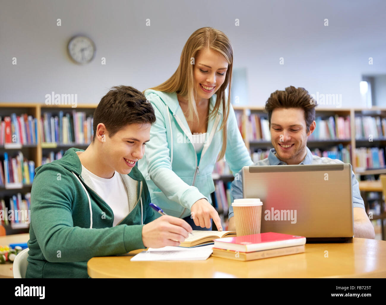 happy students with laptop and books at library Stock Photo - Alamy