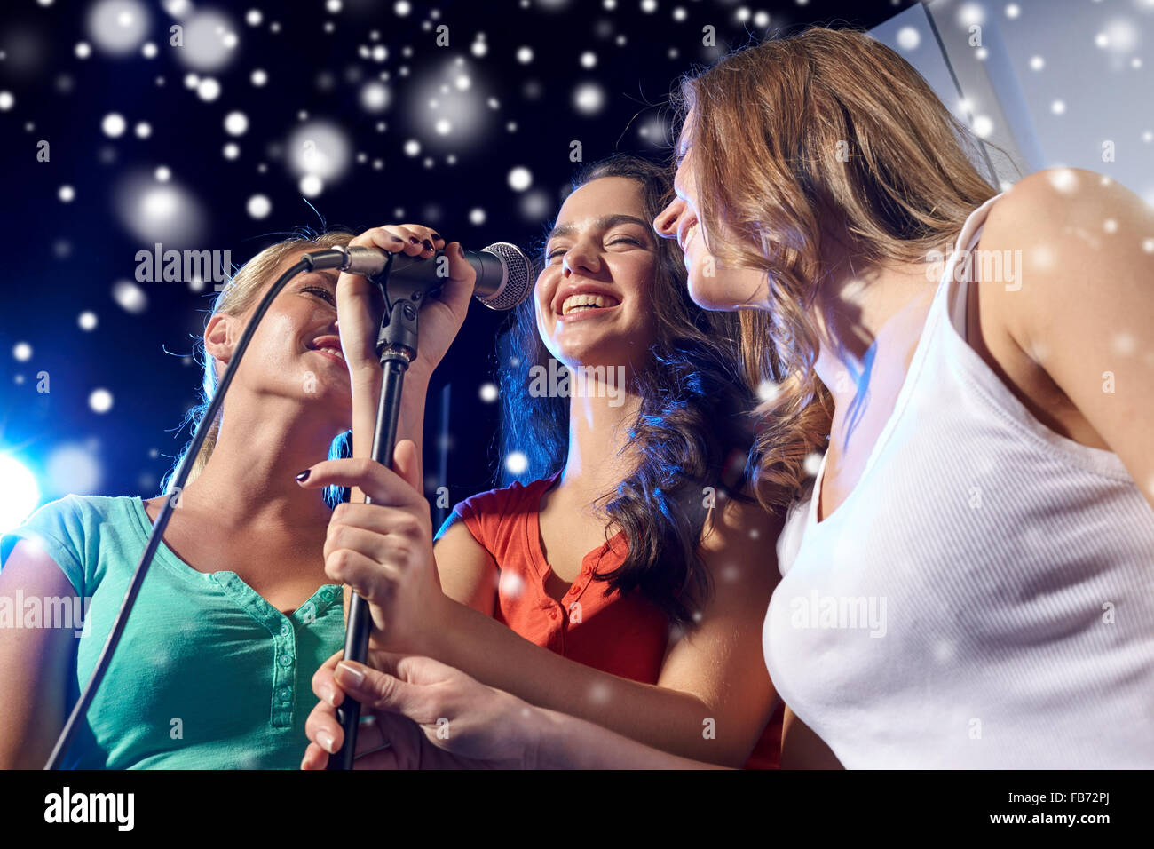 happy young women singing karaoke in night club Stock Photo - Alamy
