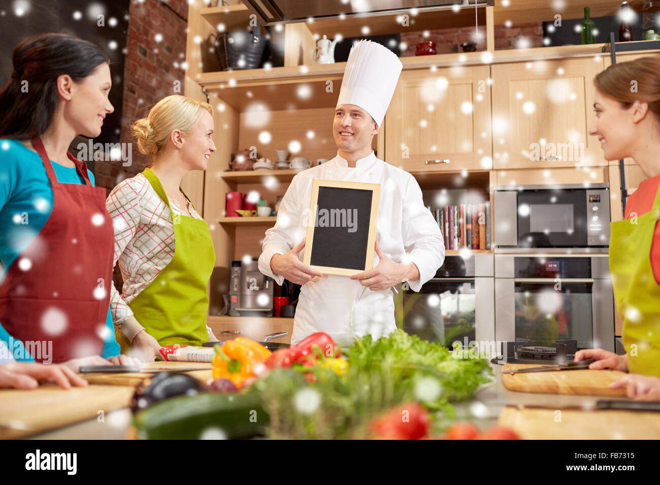 happy women and chef cook with menu in kitchen Stock Photo - Alamy