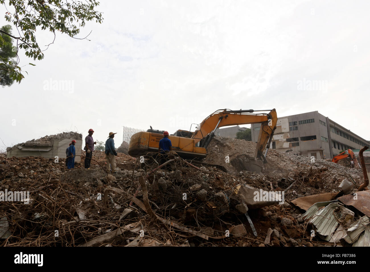Building demolition site with excavator and workers Stock Photo - Alamy