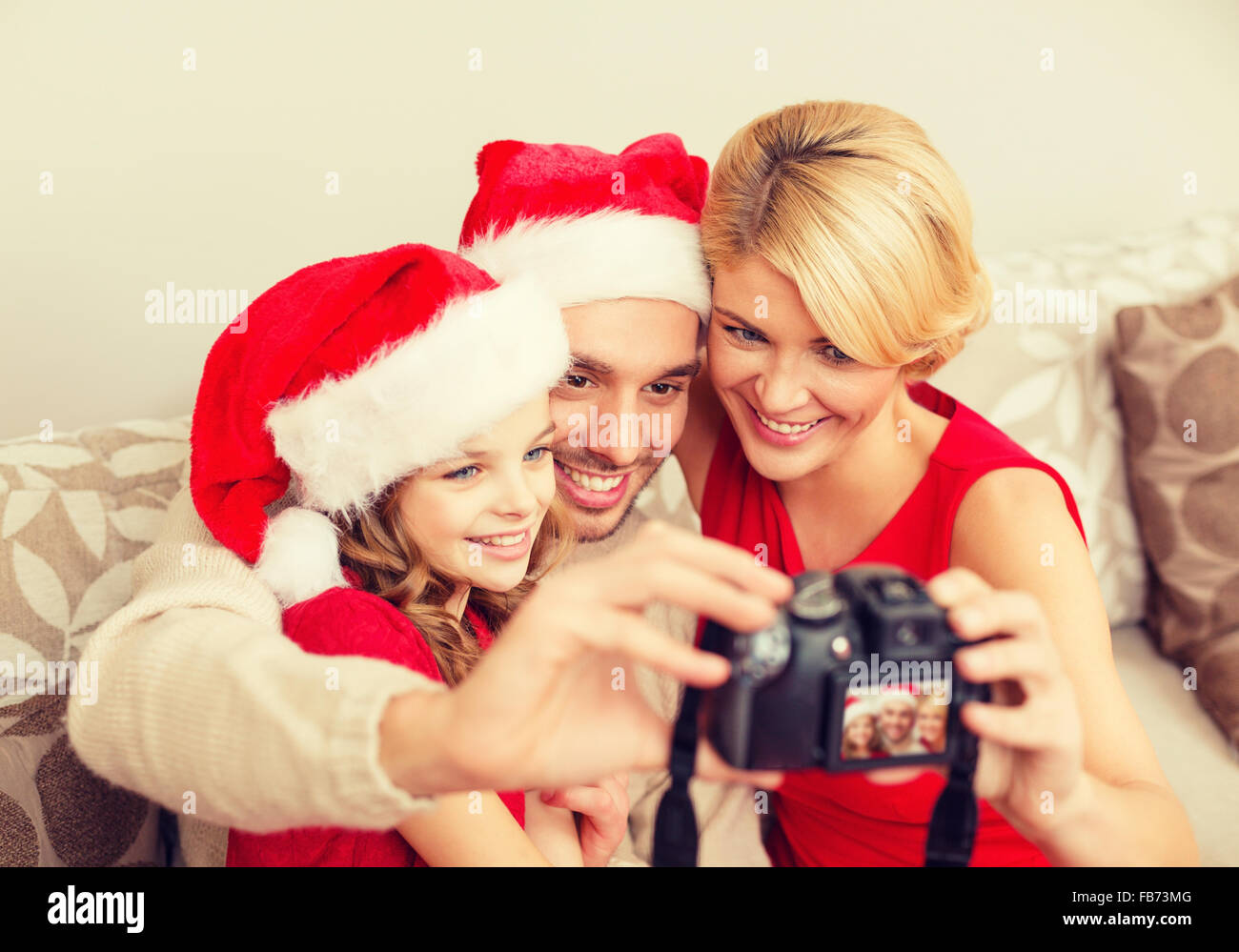 smiling family in santa helper hats taking picture Stock Photo - Alamy