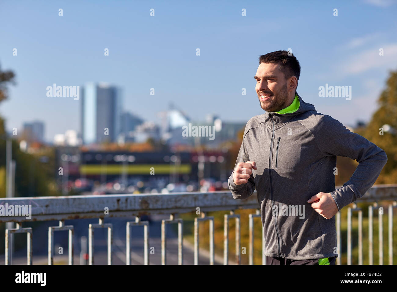 happy young man running over city bridge Stock Photo - Alamy