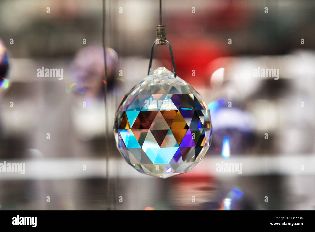 Faceted crystal hanging ball reflecting colorful light off the facets ...
