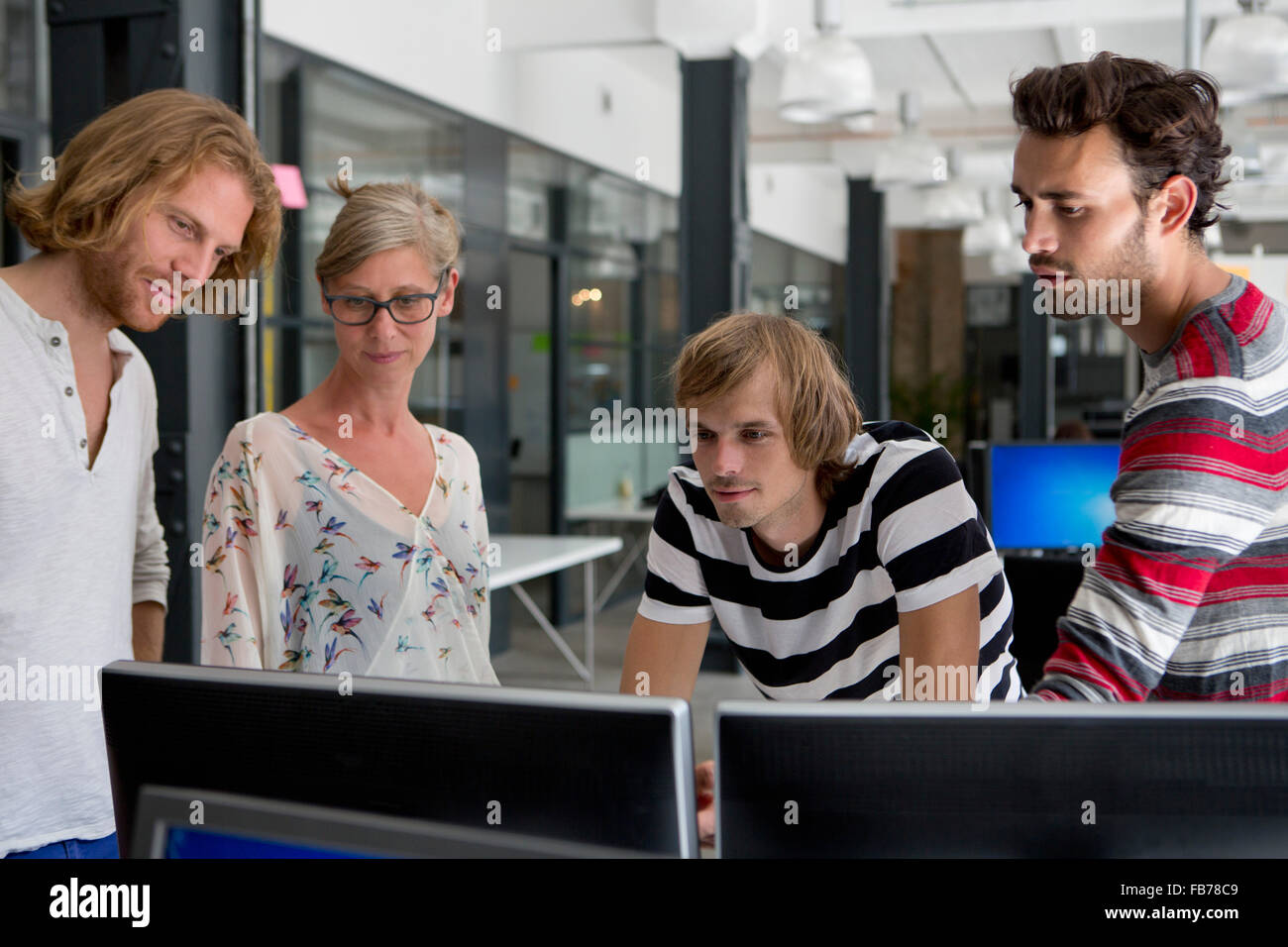 Office colleagues looking at computer in office Stock Photo - Alamy