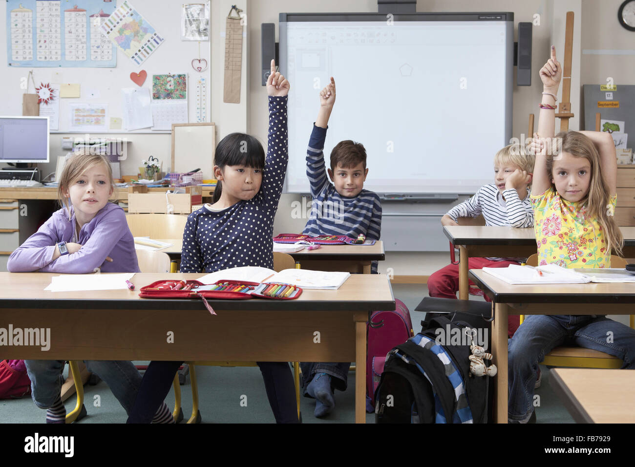 Students raising their hands in classroom Stock Photo - Alamy