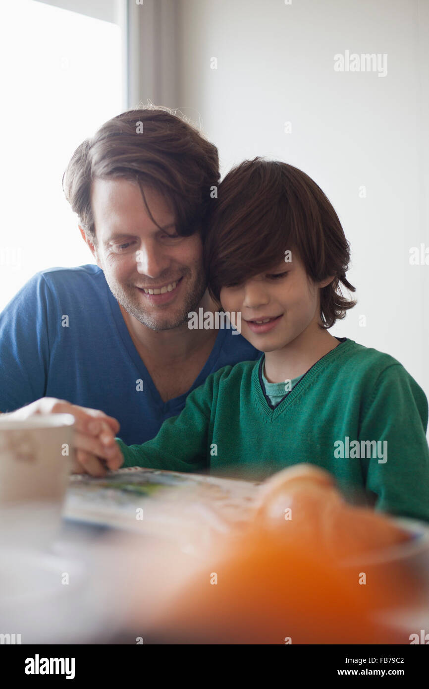 Father son smiling reading book hi-res stock photography and images - Alamy