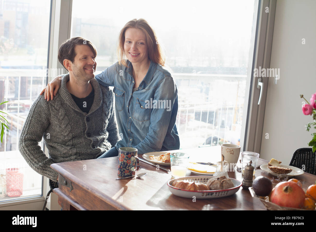 Couple sitting at dining table with breakfast Stock Photo - Alamy
