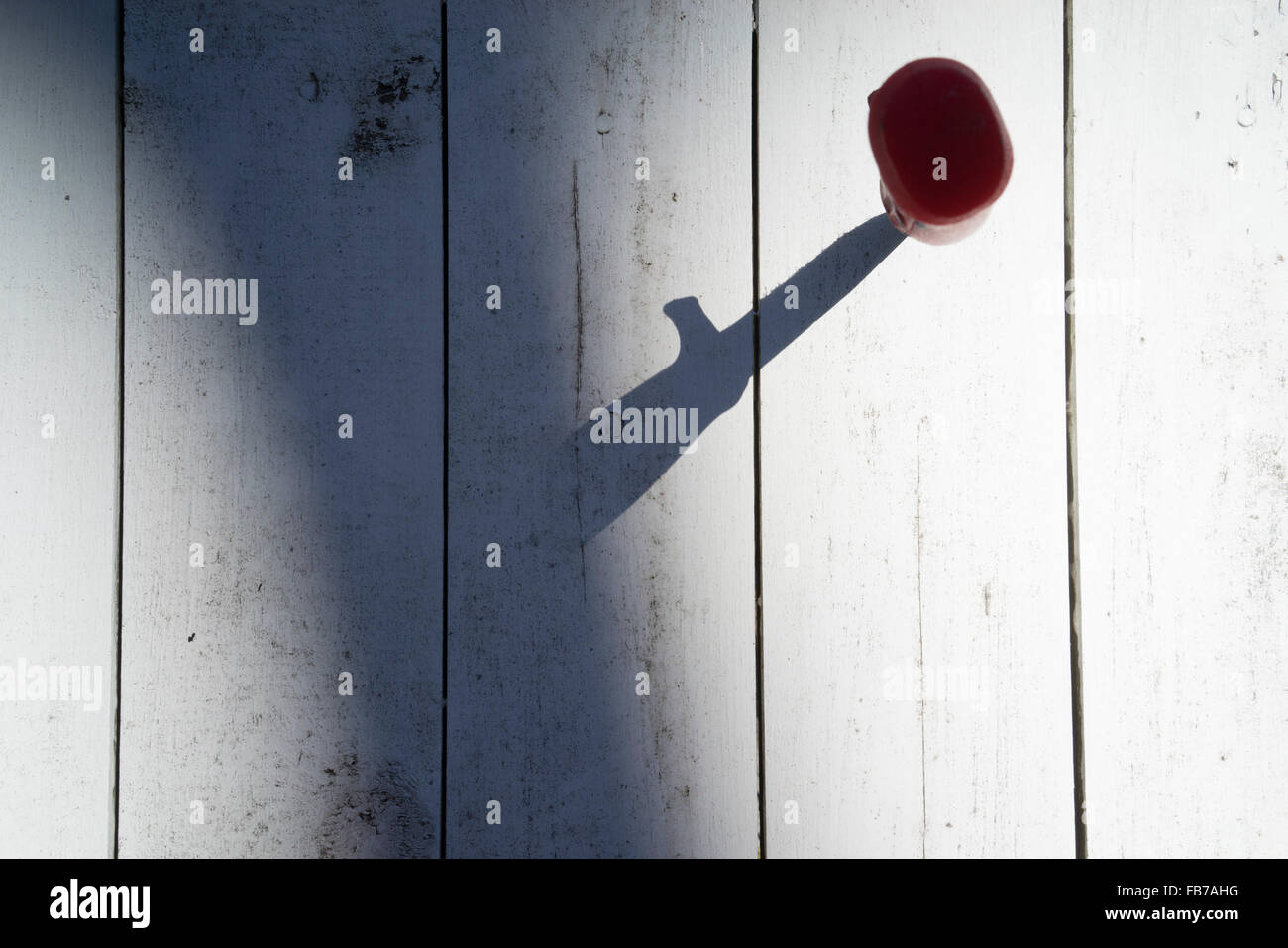 High angle view of upside down bottle with knife shadow on wood Stock ...