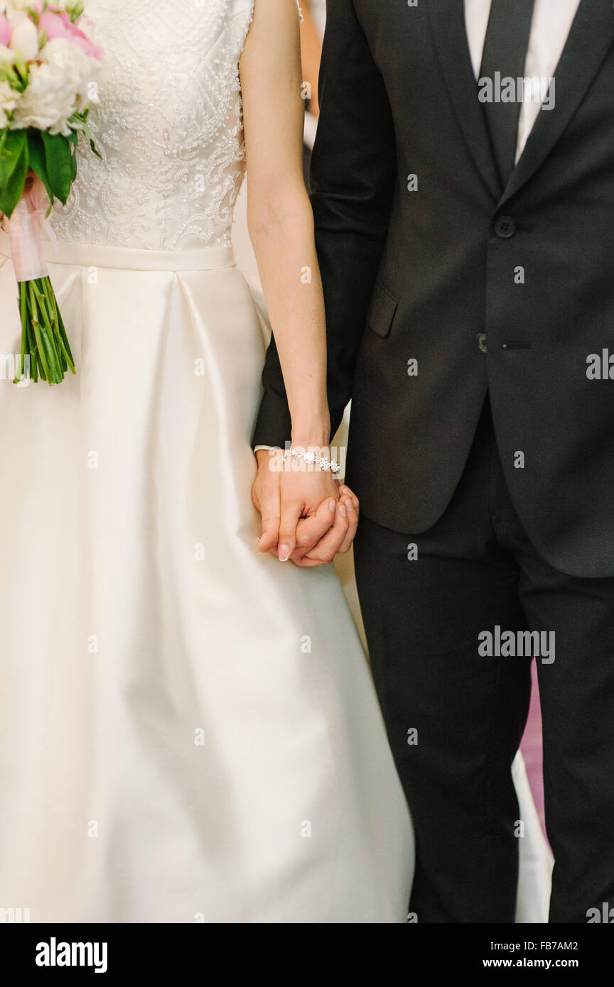 Bride and groom holding hands Stock Photo - Alamy
