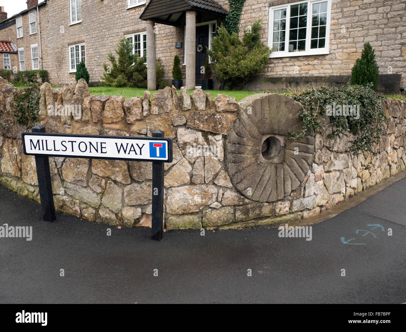 Old millstone used as part of a garden wall in Millstone Close ...