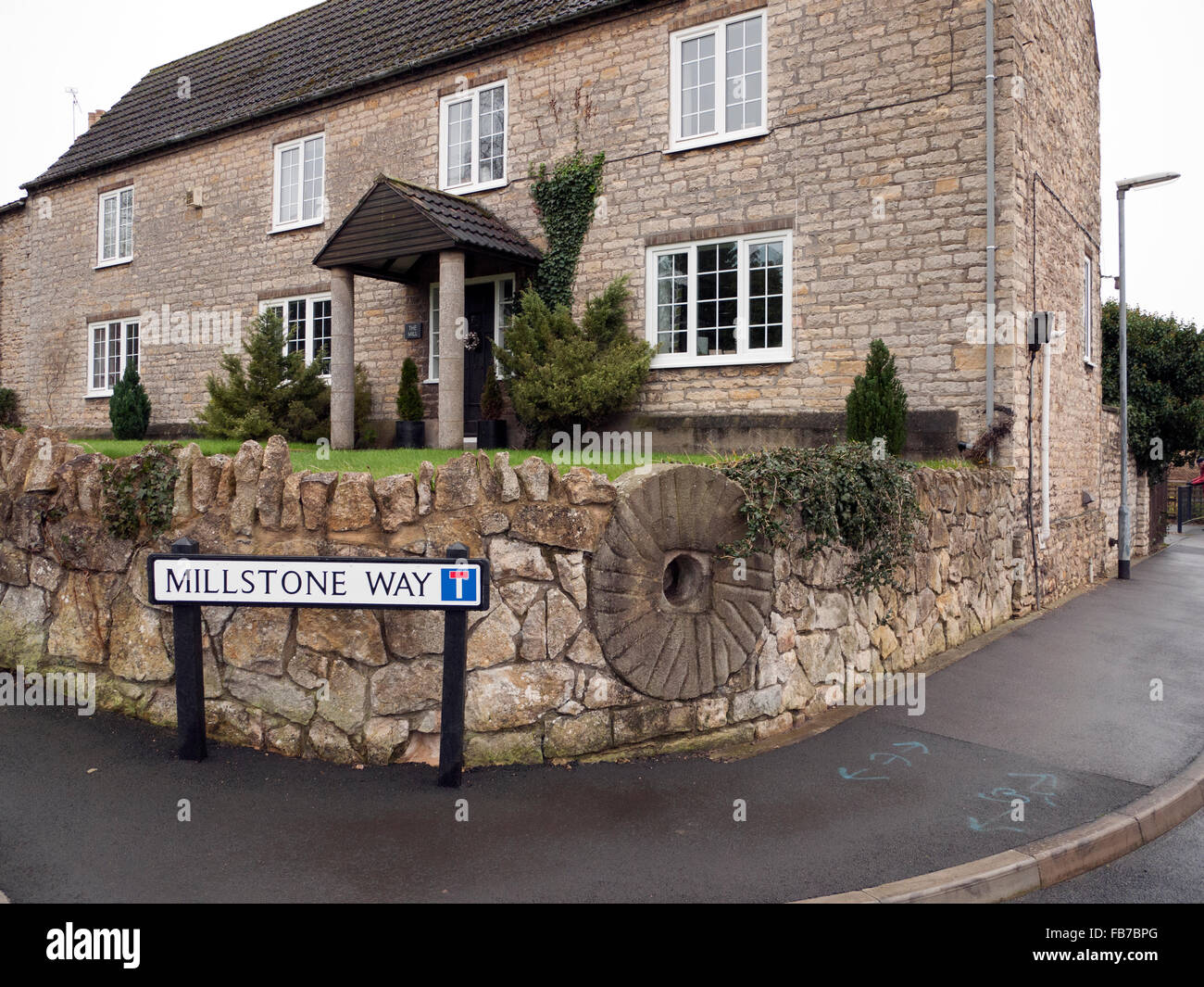 Old millstone used as part of a garden wall in Millstone Close ...