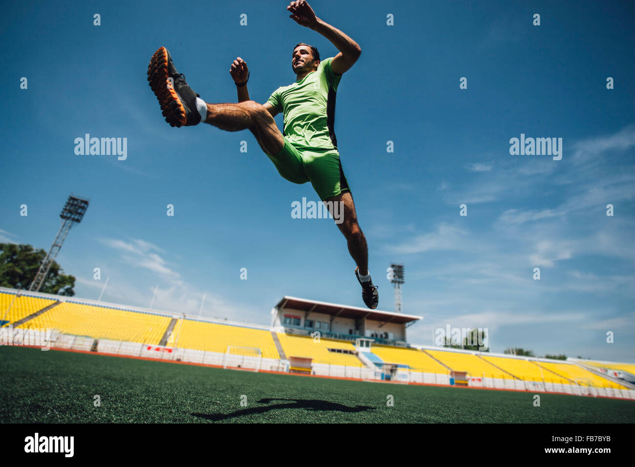 Full length of young athlete running in stadium during training Stock ...