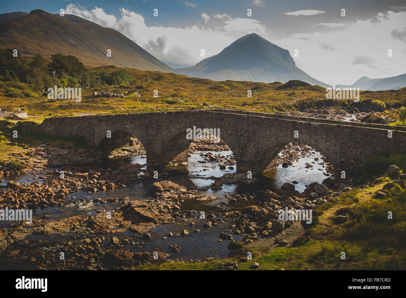 Abandoned arch bridge over stream against mountains Stock Photo - Alamy