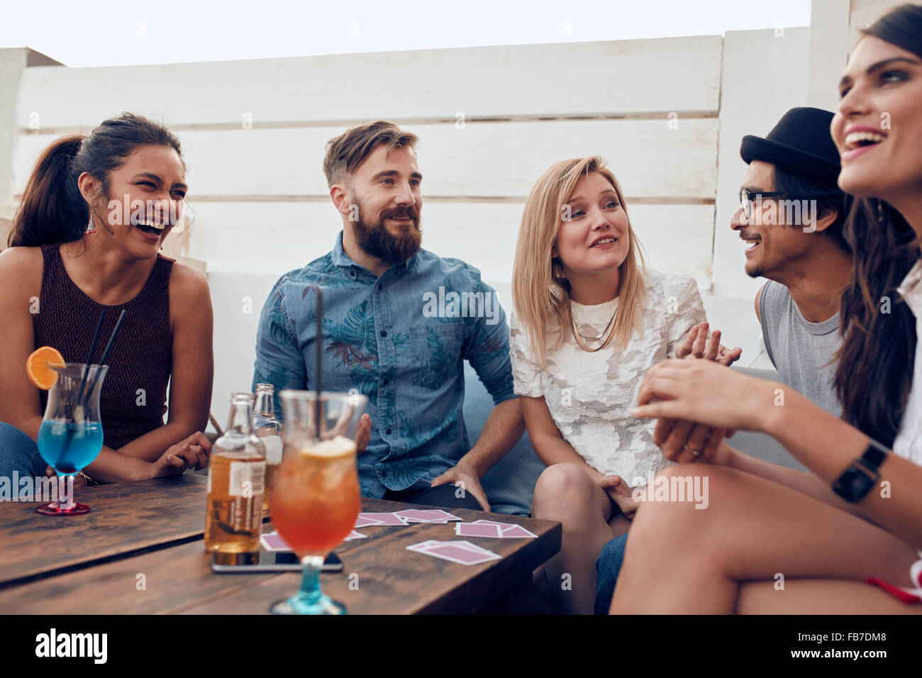 Group of friends relaxing together around a table. Young people hanging ...