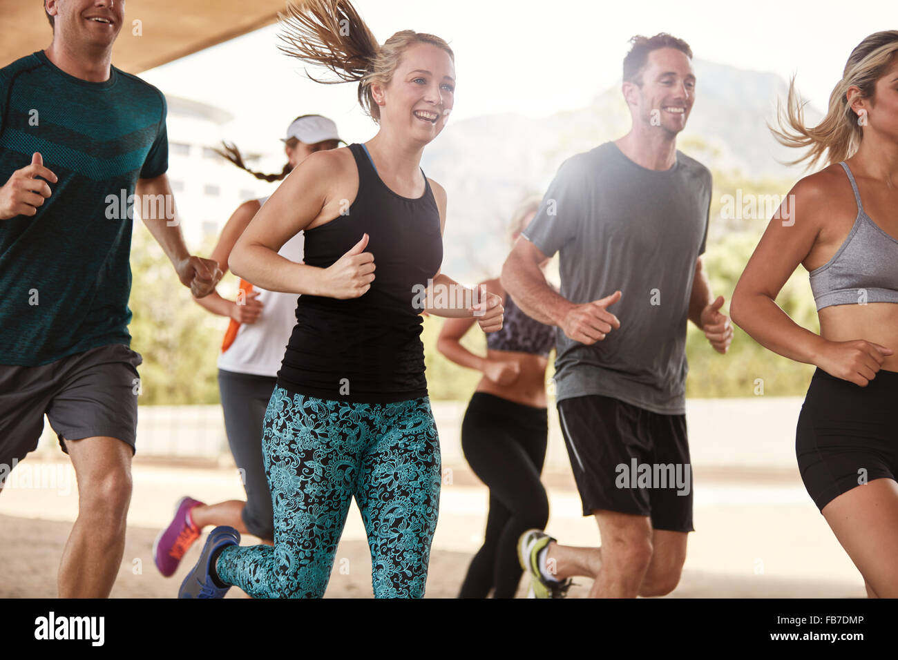 Group of happy young friends running together. Running club members ...