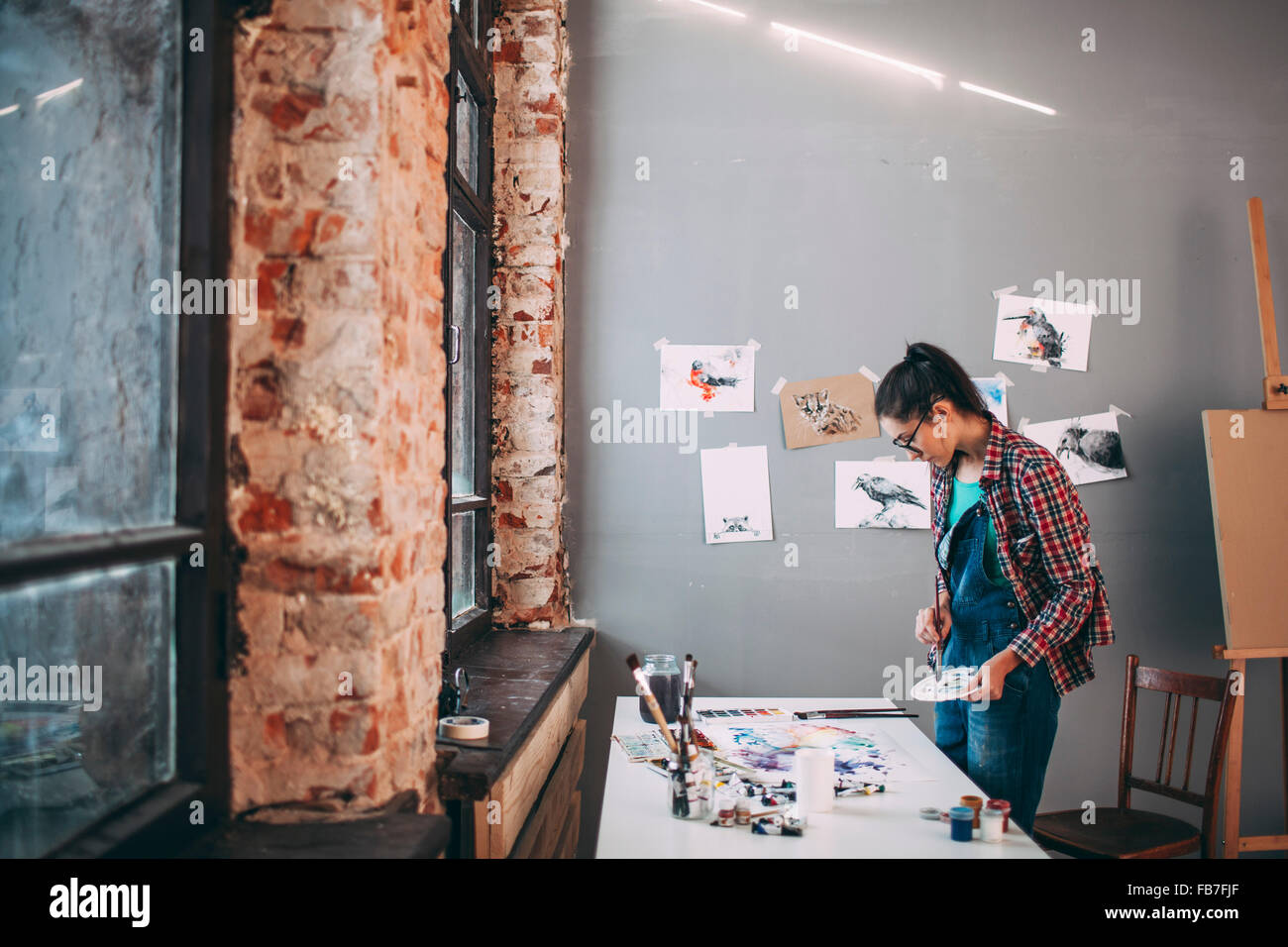Side view of artist painting at table in art studio Stock Photo - Alamy