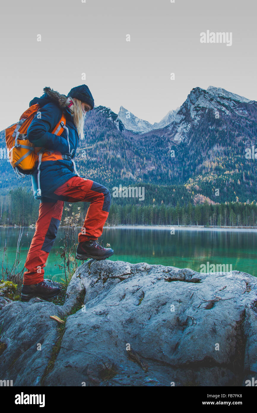 Side view of female hiker walking on rock against mountains Stock Photo ...