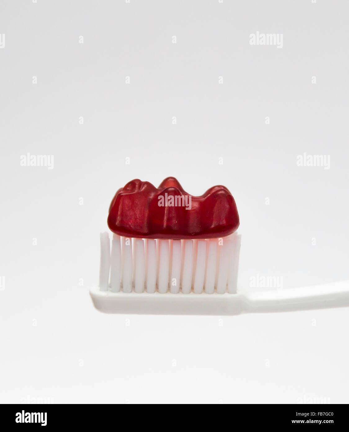 Close-up of gummy bear on toothbrush against white background Stock ...