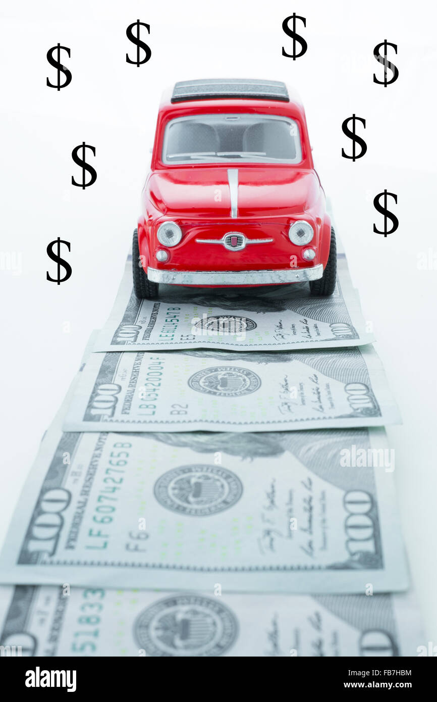 A car driving on a road paved with money, symbolising the road to ...