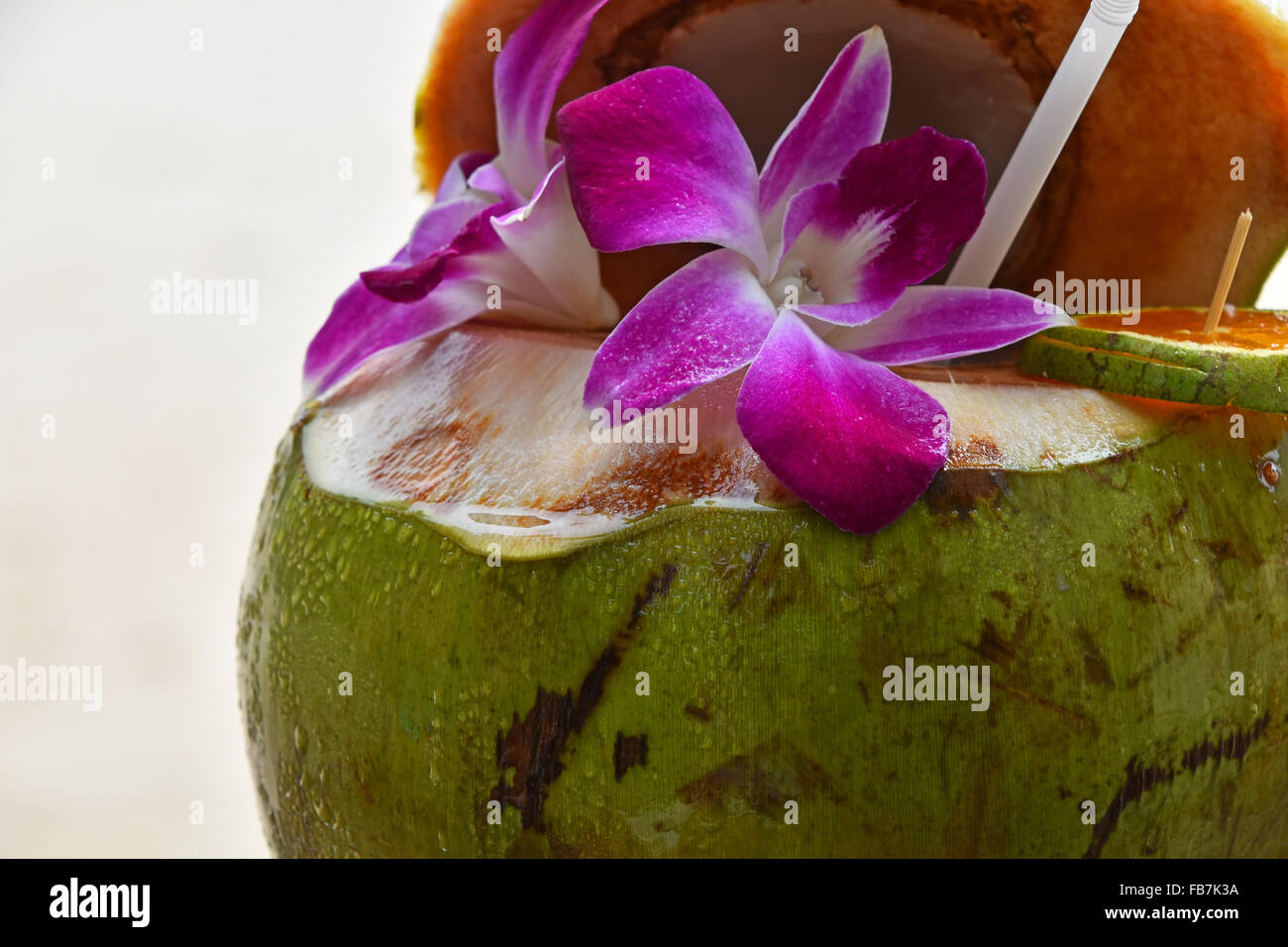 Fresh open green coconut milk juice with straw decorated garnished with ...