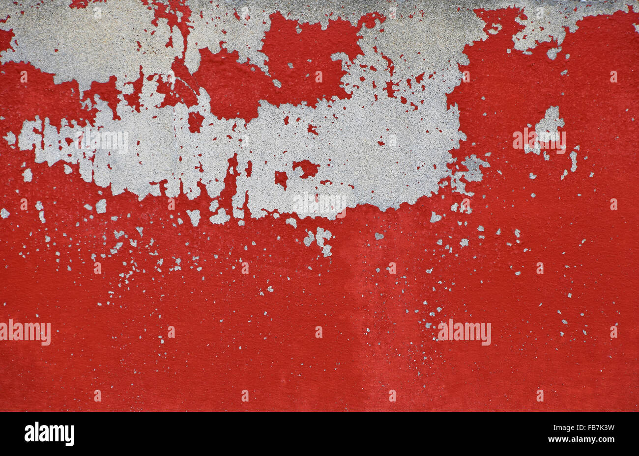 Flakes of old vintage grungy bright vivid red paint on grey concrete ...