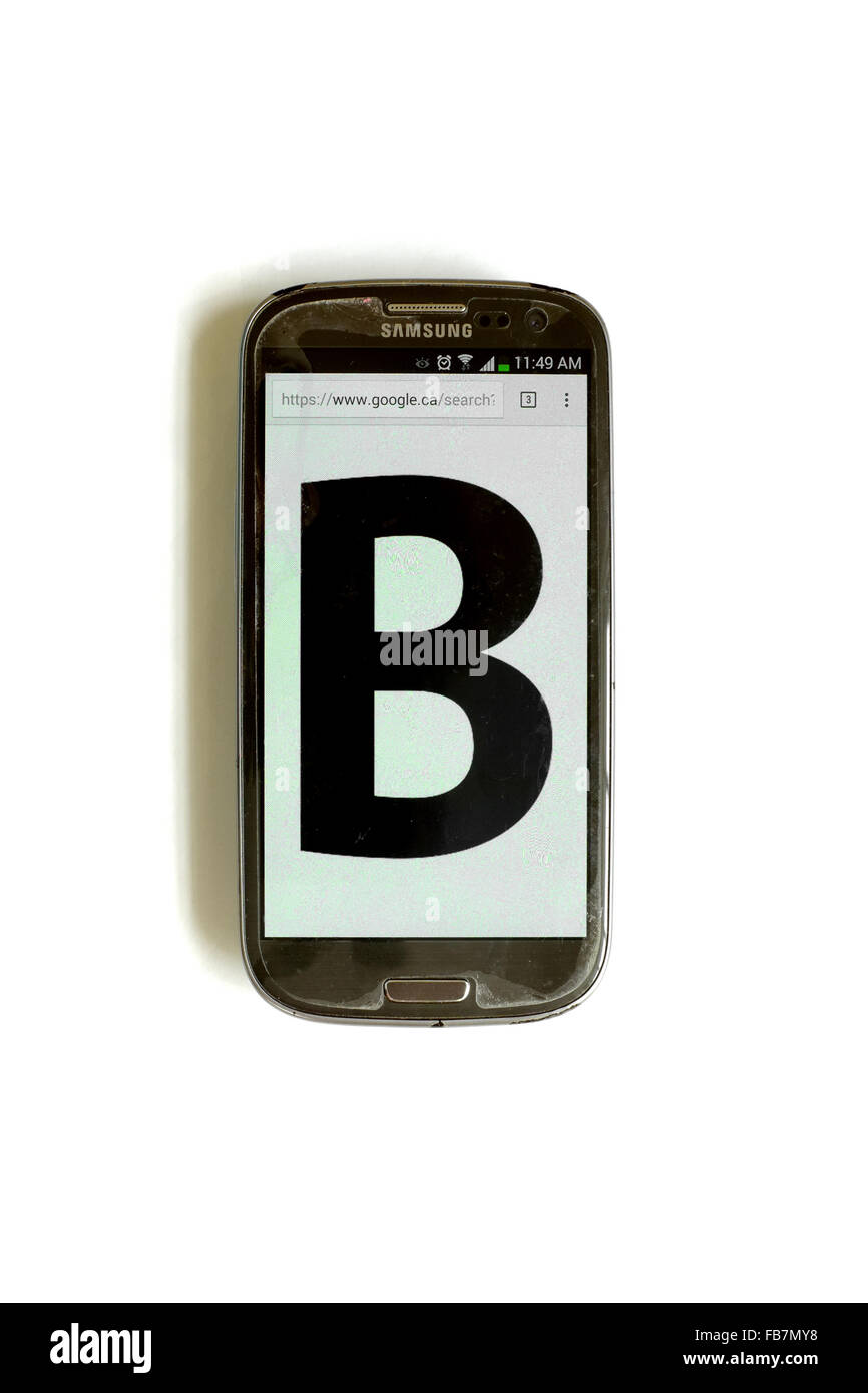 The letter B written on the screen of a smartphone photographed against ...