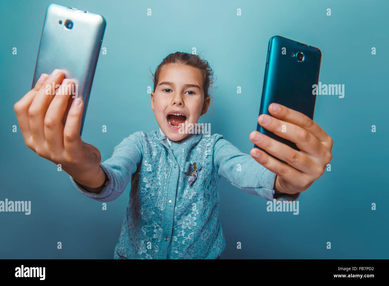 teen girl of European appearance seven years, holding two tele Stock ...