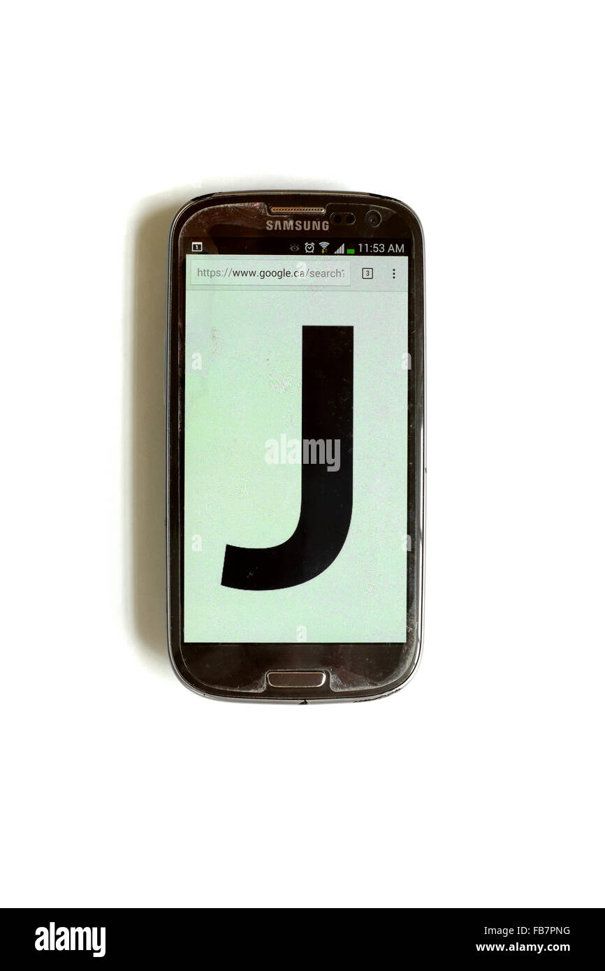 The letter J written on the screen of a smartphone photographed against ...