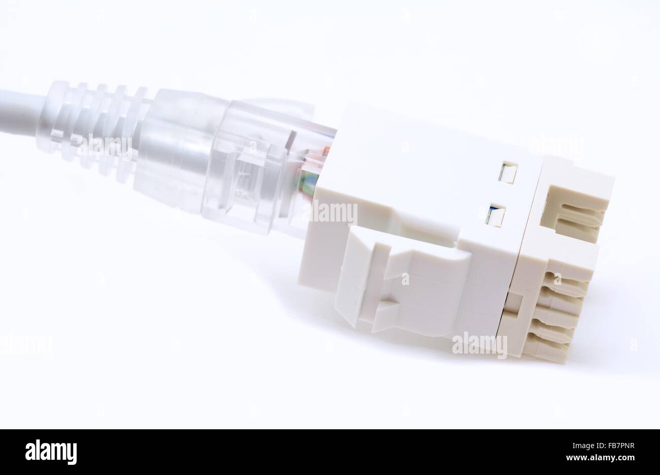 Gray ethernet Cat5e cable plugs to the RJ45 keystone on a white ...