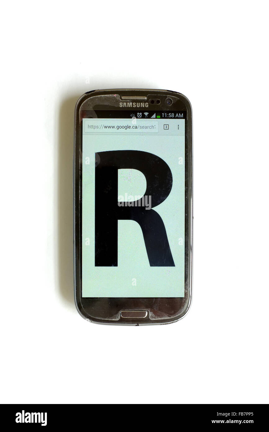 The letter R written on the screen of a smartphone photographed against ...